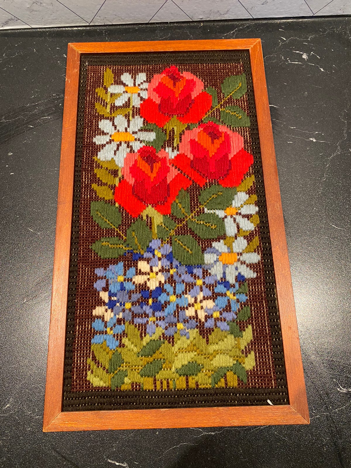 Retro brodert bilde av roser, hestehov m.fl, sort bakgrunn med treramme | FINN-torget