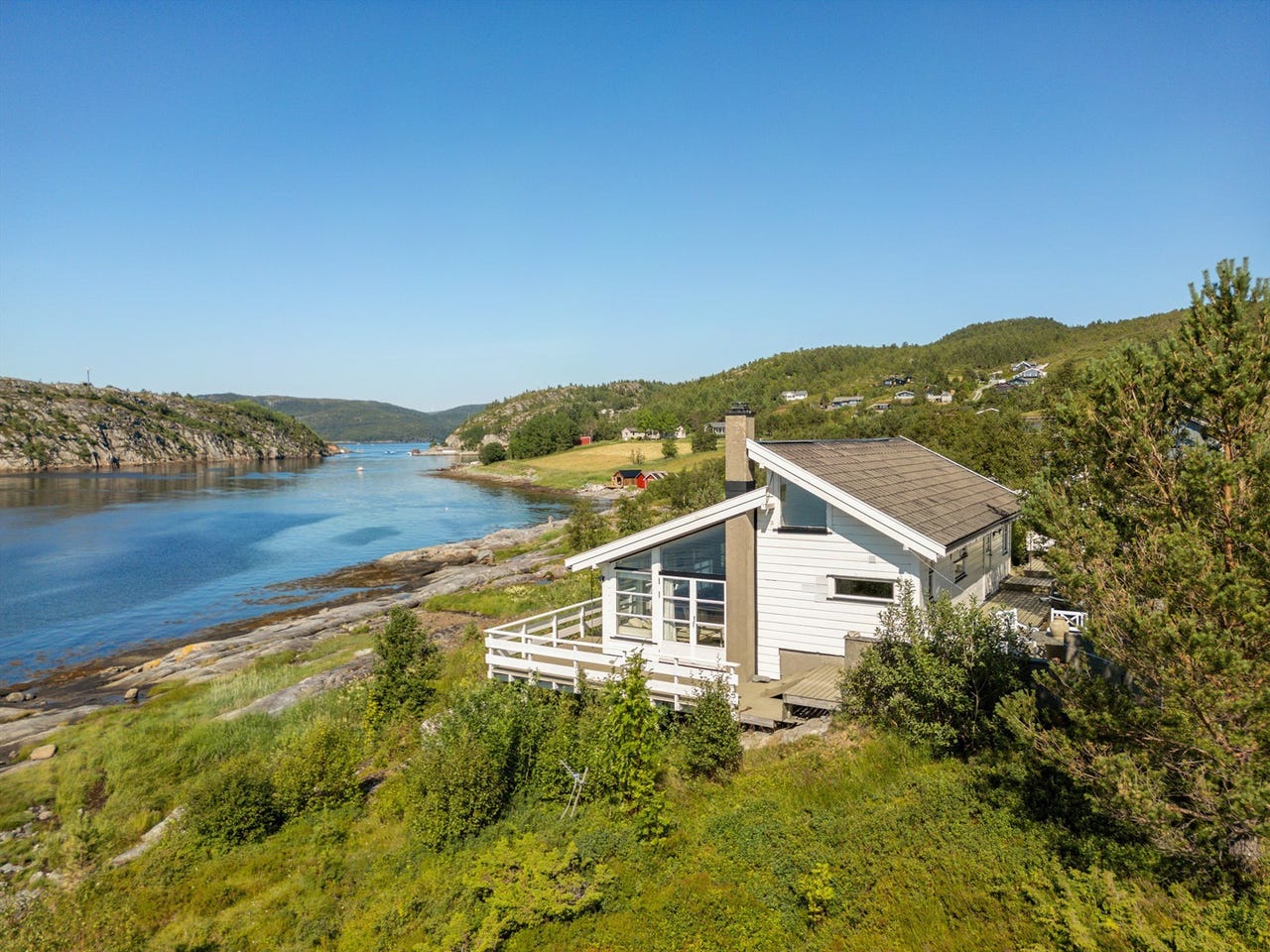 Fritidseiendom med idyllisk beliggenhet ved sjøkanten, omringet av ...
