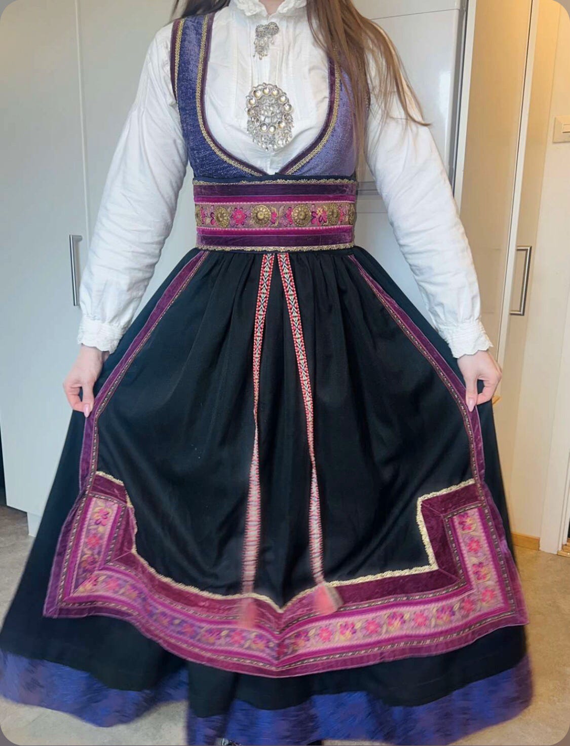 Valland festdrakt i lilla, rosa farger, med skjorte, forkle, belte. Str ...