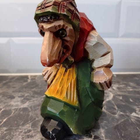 Treskulptur med figur som røyker pipe og røde terninger | FINN-torget